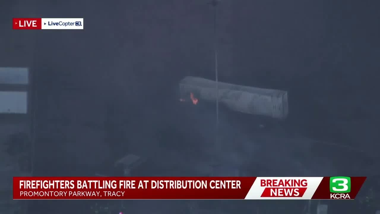 Aerial shots show big rig in flames at distribution center