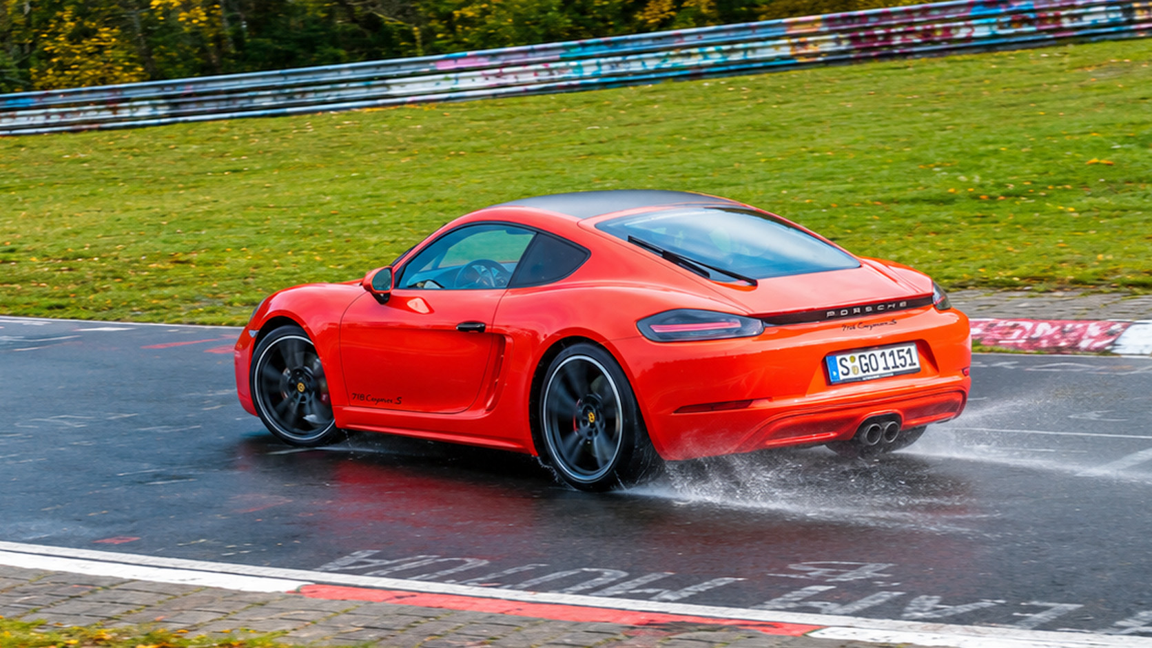 Porsche driver slides off mid-corner on a wet track