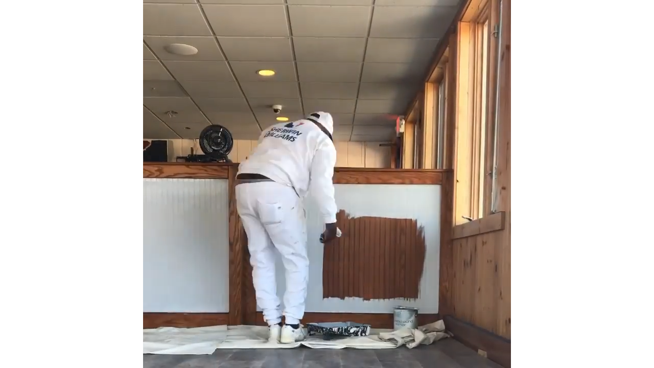 Rolling warm brown paint on interior wall panel creating rich wood ...