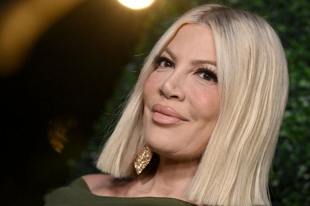 Tori Spelling slumps against wall after hours in the sun during ...