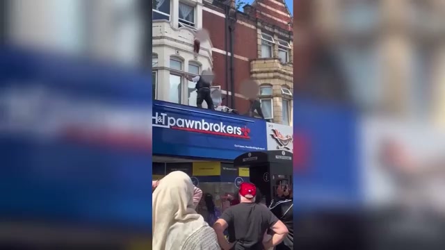 Child dangling from rooftop window rescued by police and bystanders