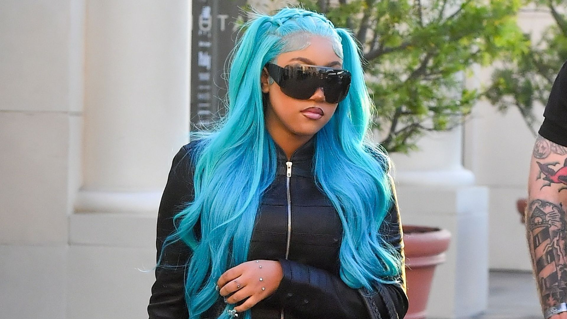 North West rocks an all-leather look, hand piercings and signature blue ...