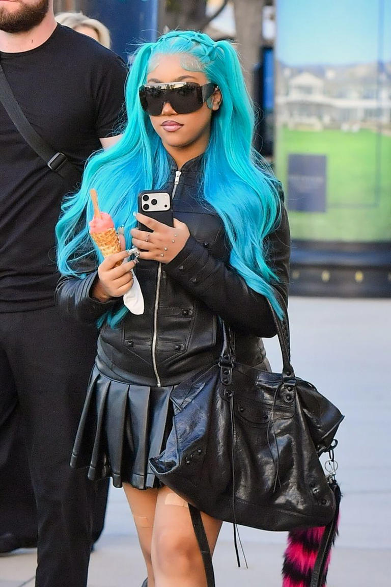 North West rocks an all-leather look, hand piercings and signature blue ...