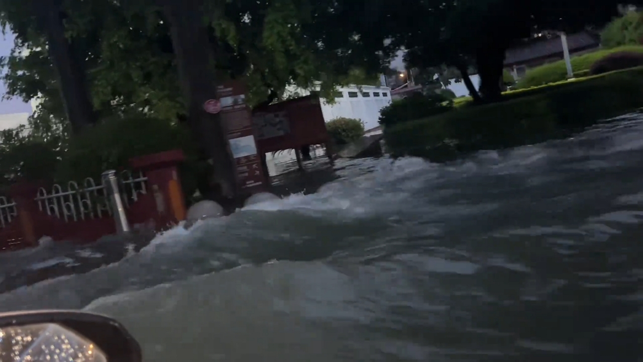 Car navigates deep flood in Guangdong neighborhood