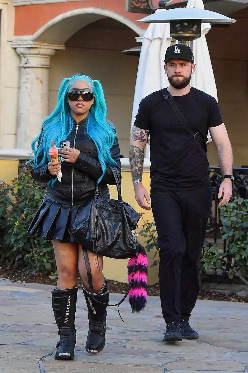 North West rocks an all-leather look, hand piercings and signature blue ...