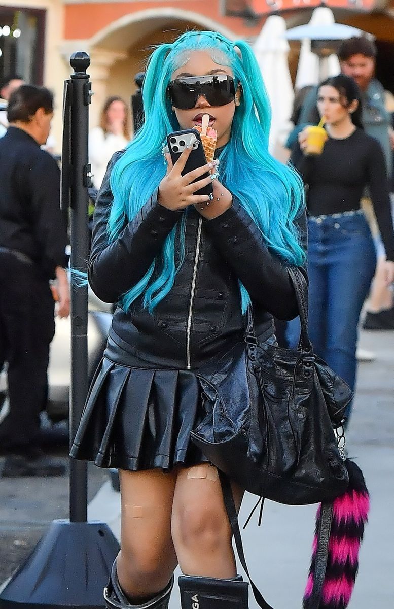 North West rocks an all-leather look, hand piercings and signature blue ...