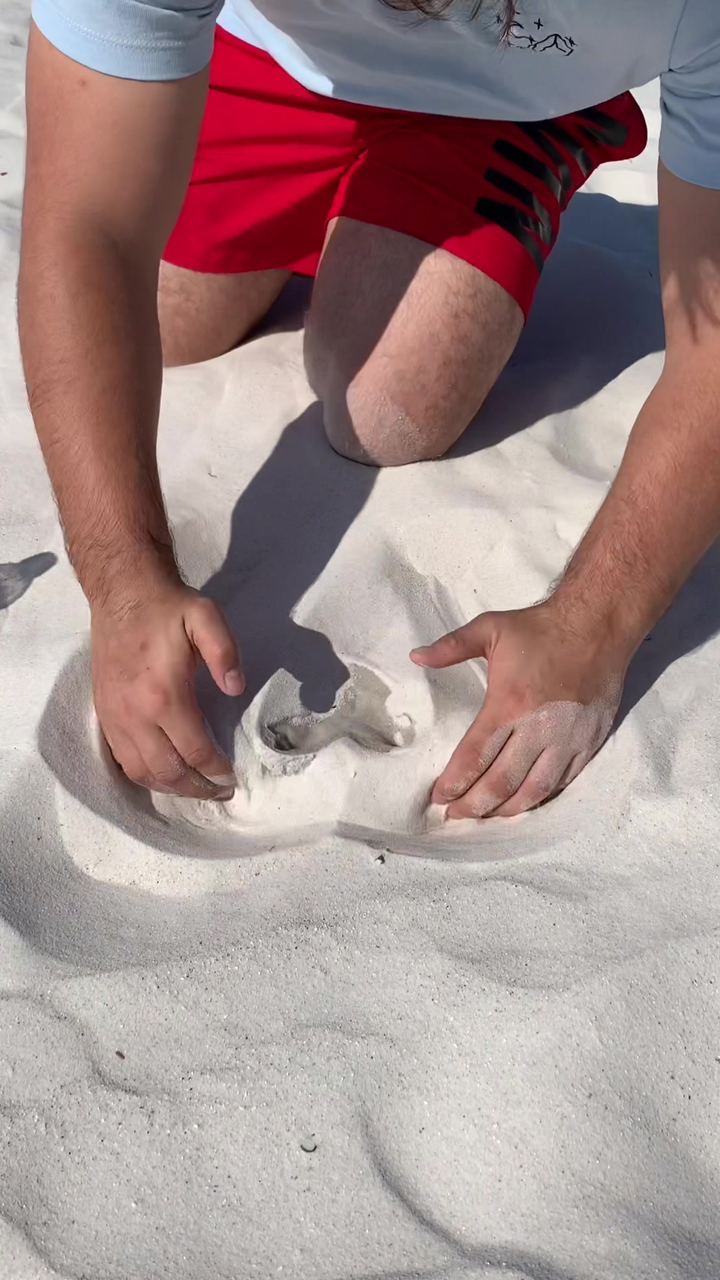 Creating a heart in sand at sunset: Calm and beautiful moment