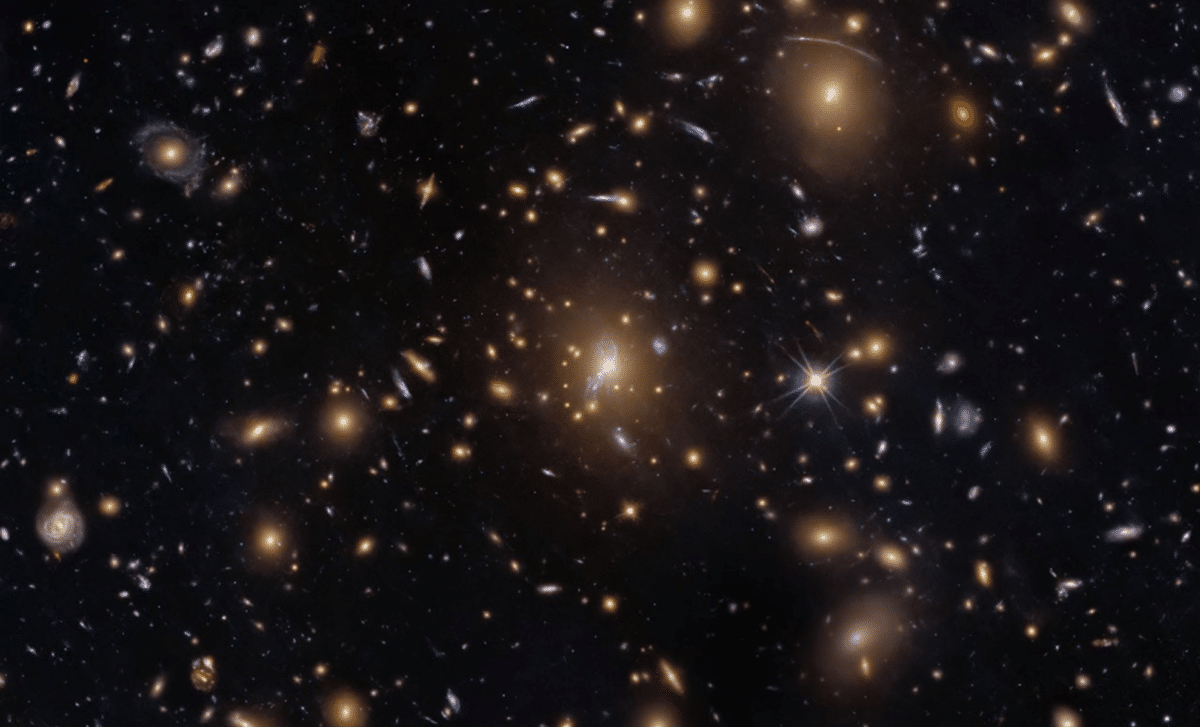 Hubble captures a cosmic swarm that is bending light across the universe