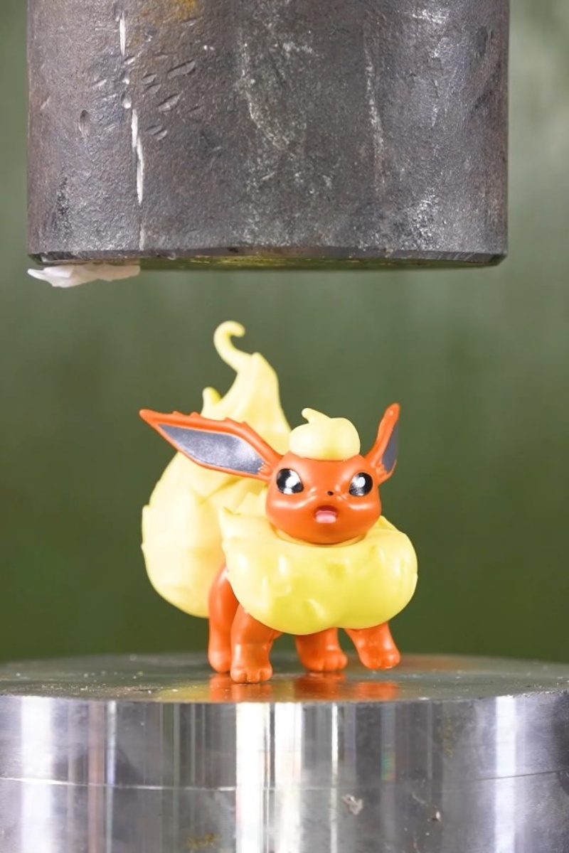 Prasa hydrauliczna miażdży zabawkę Flareon