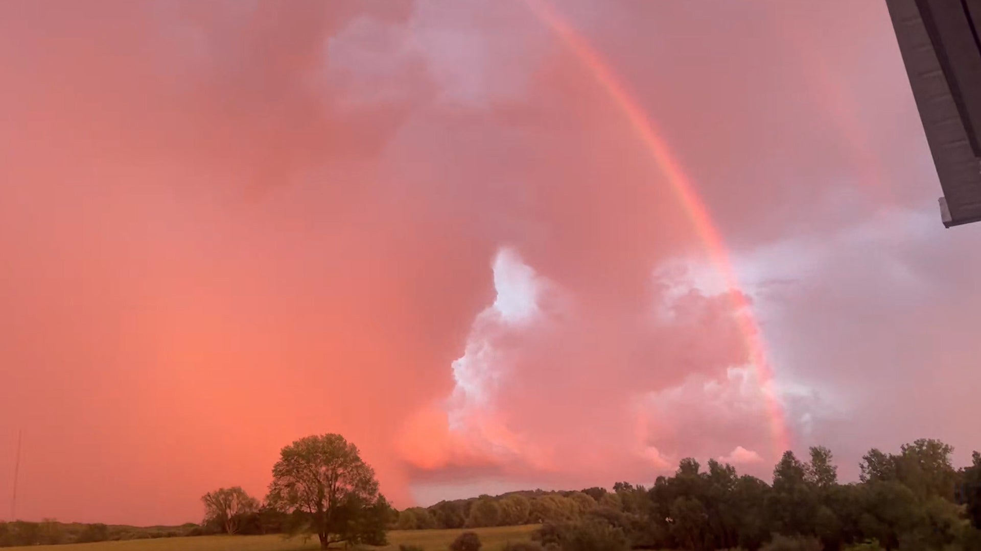 Mesmerizing double rainbow frames storm clouds painted by sunset