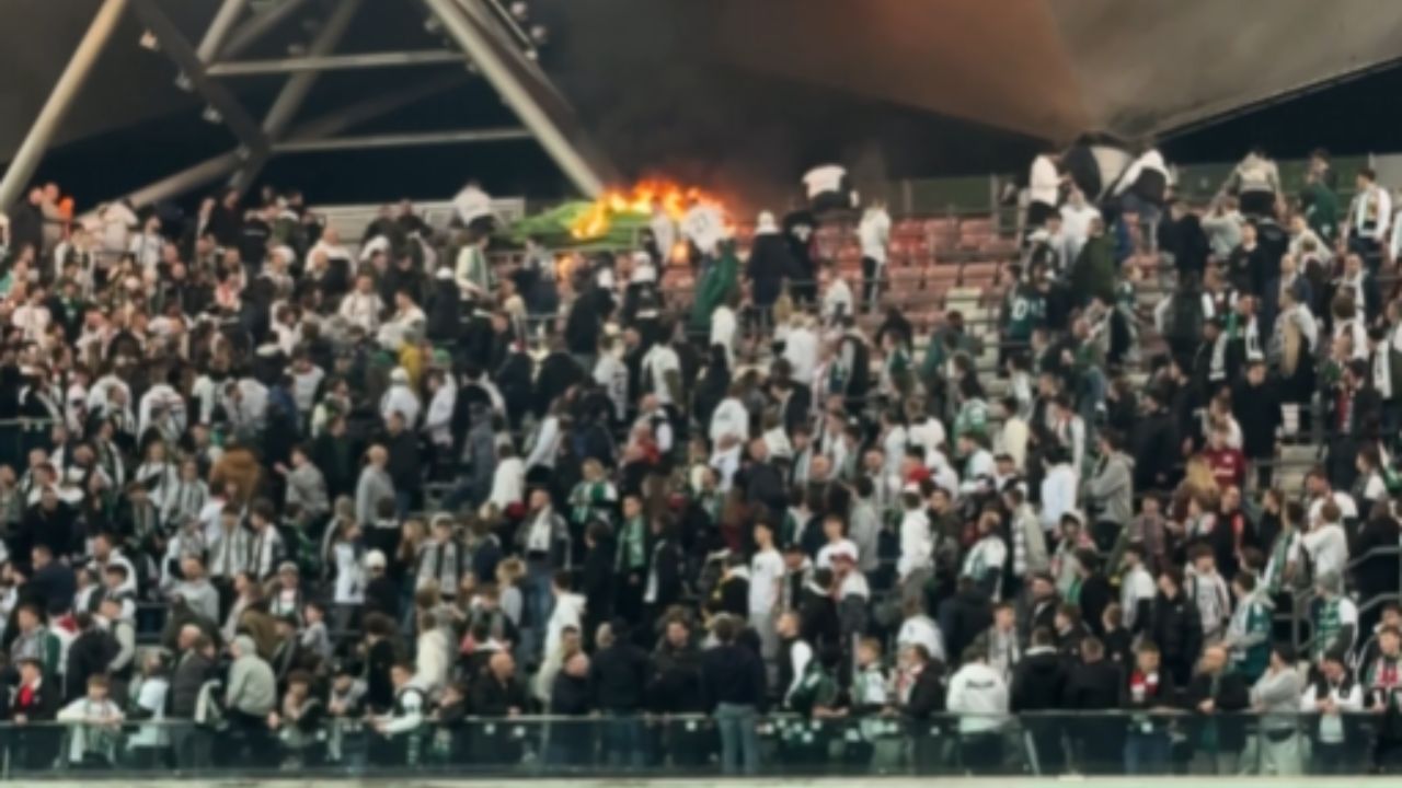 Legia Warszawa fans light flares and set part of stadium stand on fire