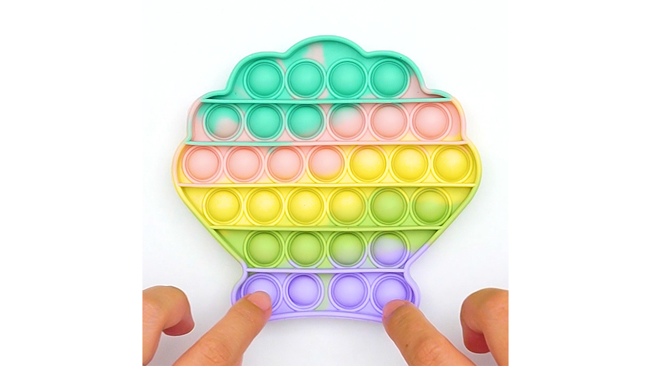 Playing with a colorful ice cream shaped pop it in soft gradient colors