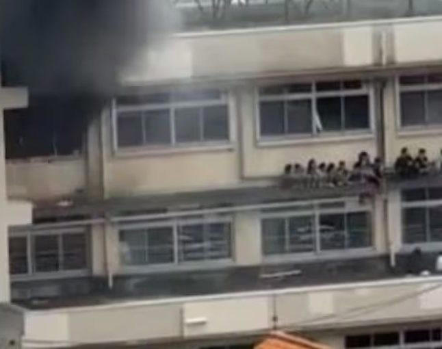 Children cower on a ledge while fleeing fire that engulfed their school