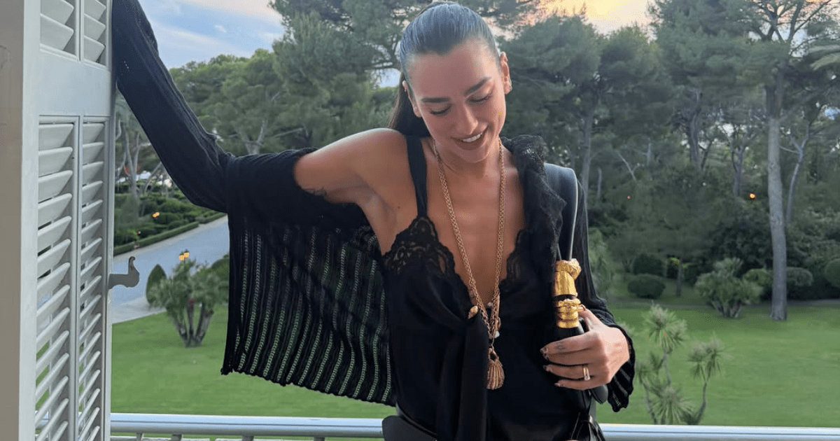Dua Lipa styles lacy cami top hanging by strings with $5K Schiaparelli bag