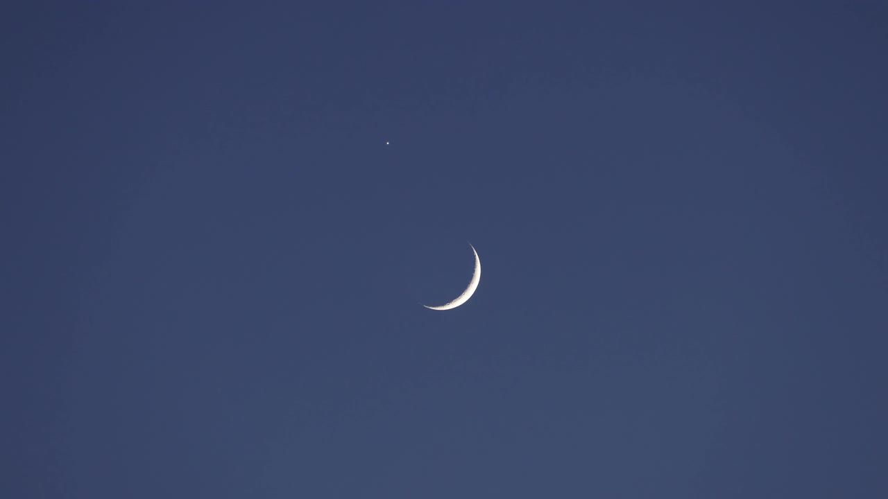 Spectacular footage as crescent moon and Venus align in night sky