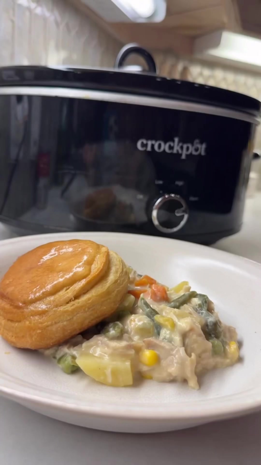 Making cozy chicken pot pie in the crockpot with a soft golden biscuit ...