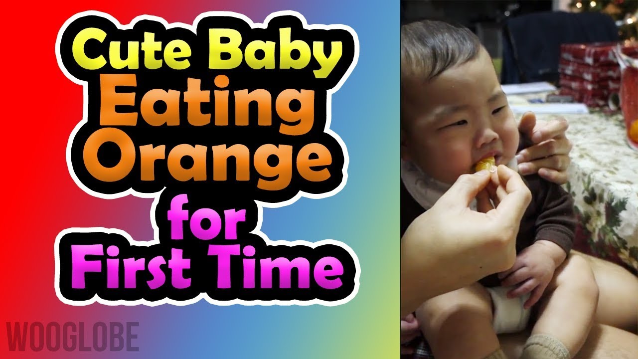 Funny baby tries eating orange for the first time