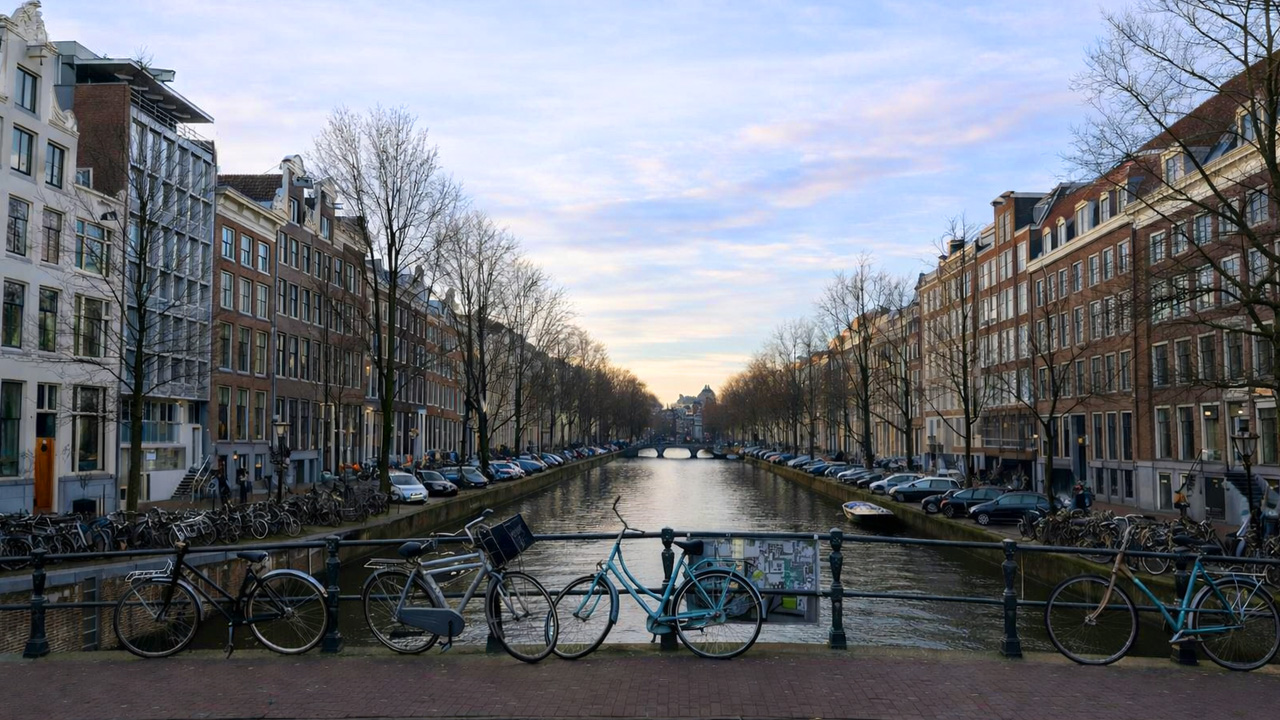 Amsterdam sunset walk past bikes and canal houses