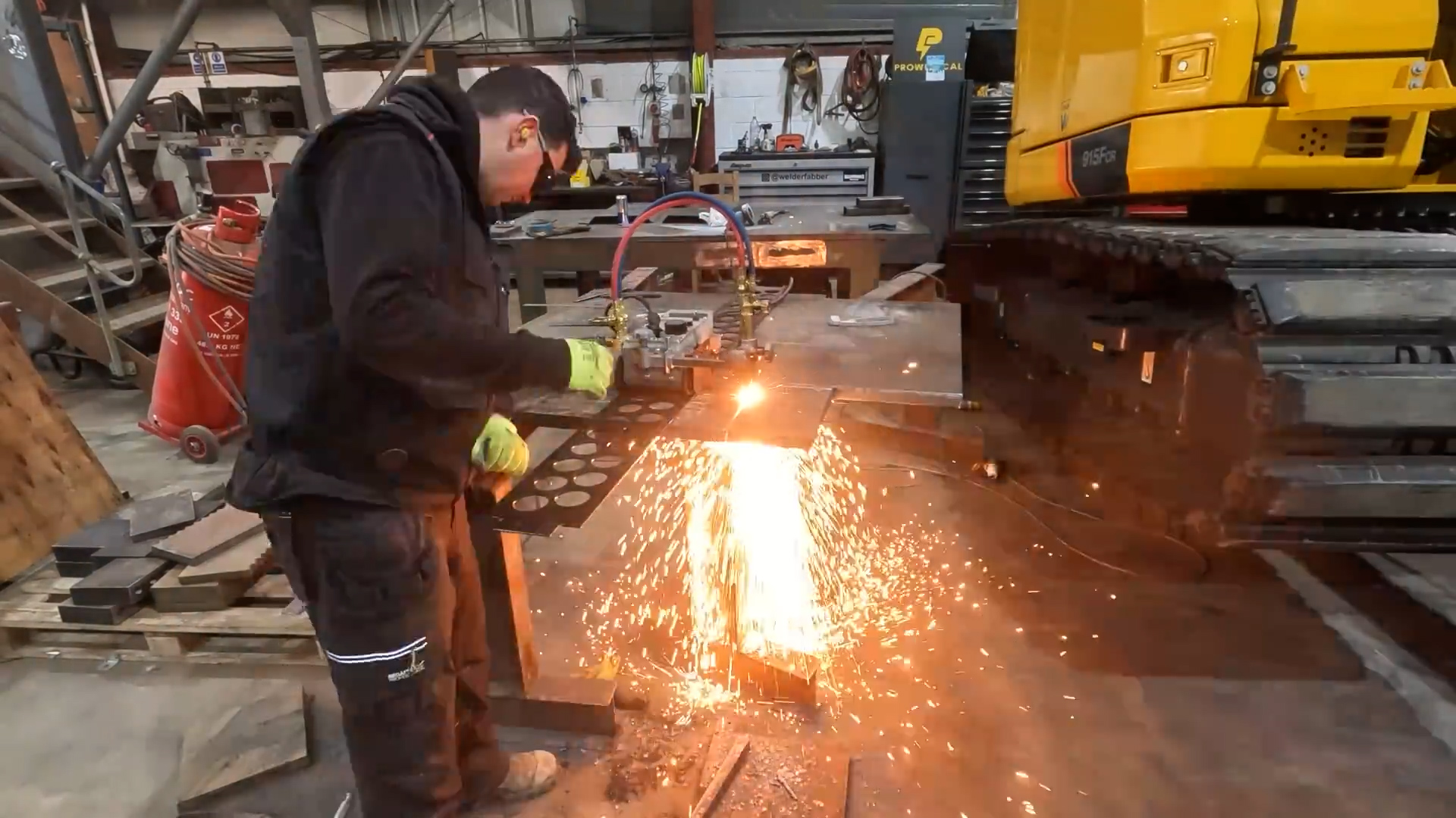 Engineer operating CNC plasma cutter during steel fabrication process