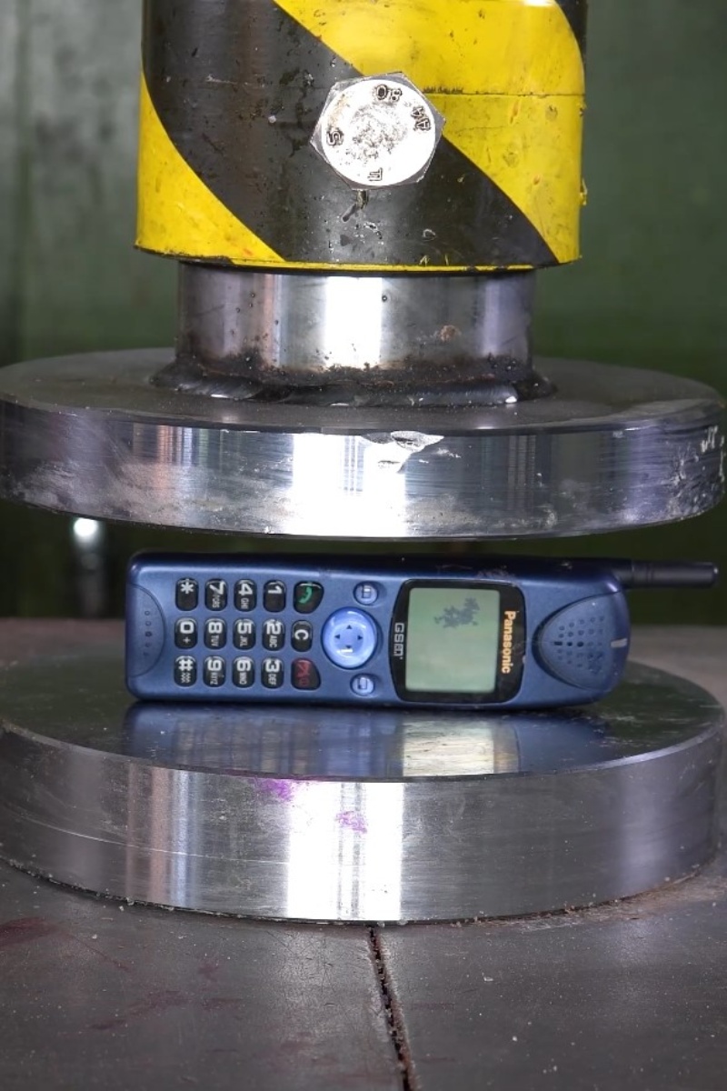 Prasa hydrauliczna miażdży stary telefon