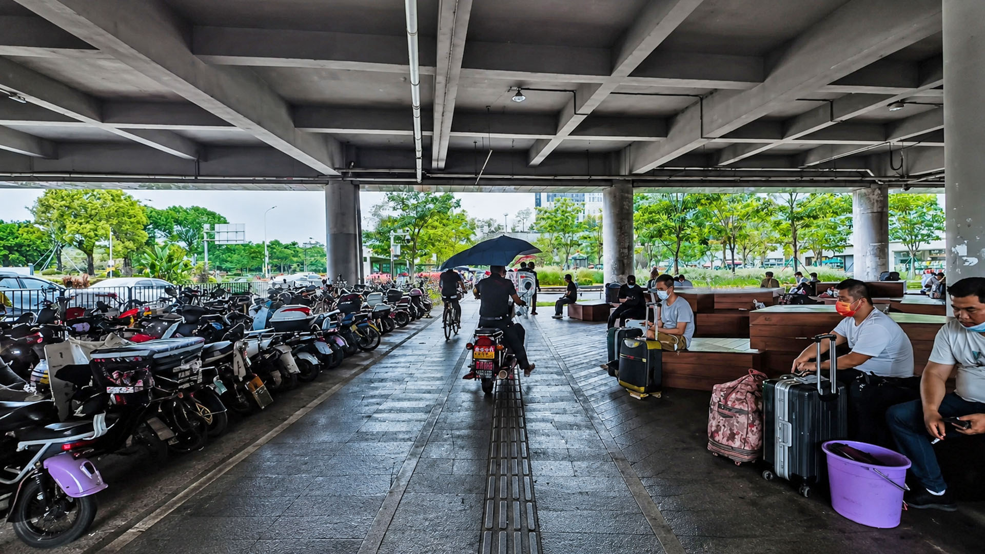 Rainy day street scene in China under a covered city walkway
