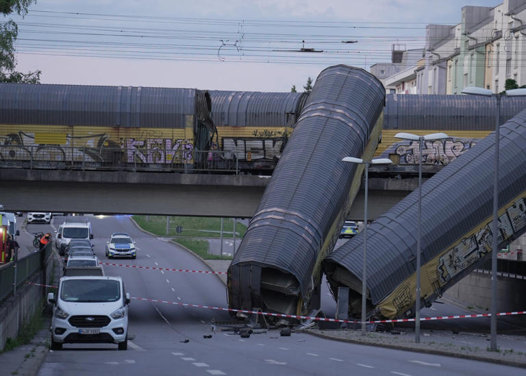 One dead as freight train goods wagons plunge off bridge