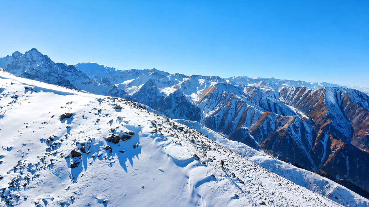 Snow-covered mountains glowing under intense alpine sunlight