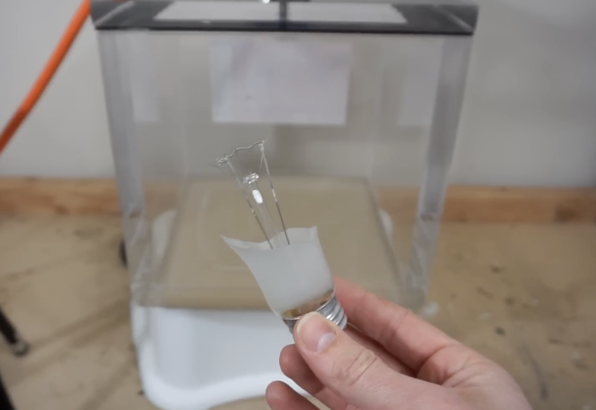 What happens when you turn on a broken light bulb in a vacuum chamber?