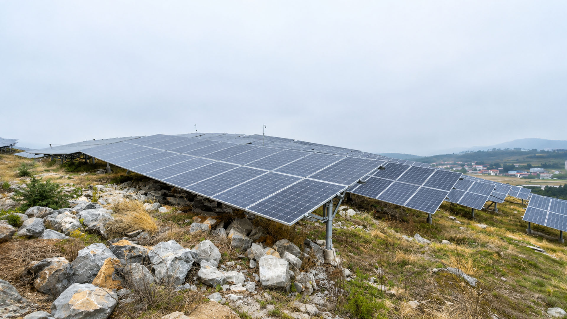 Sunlight harvesting begins on a rugged hillside above a small village