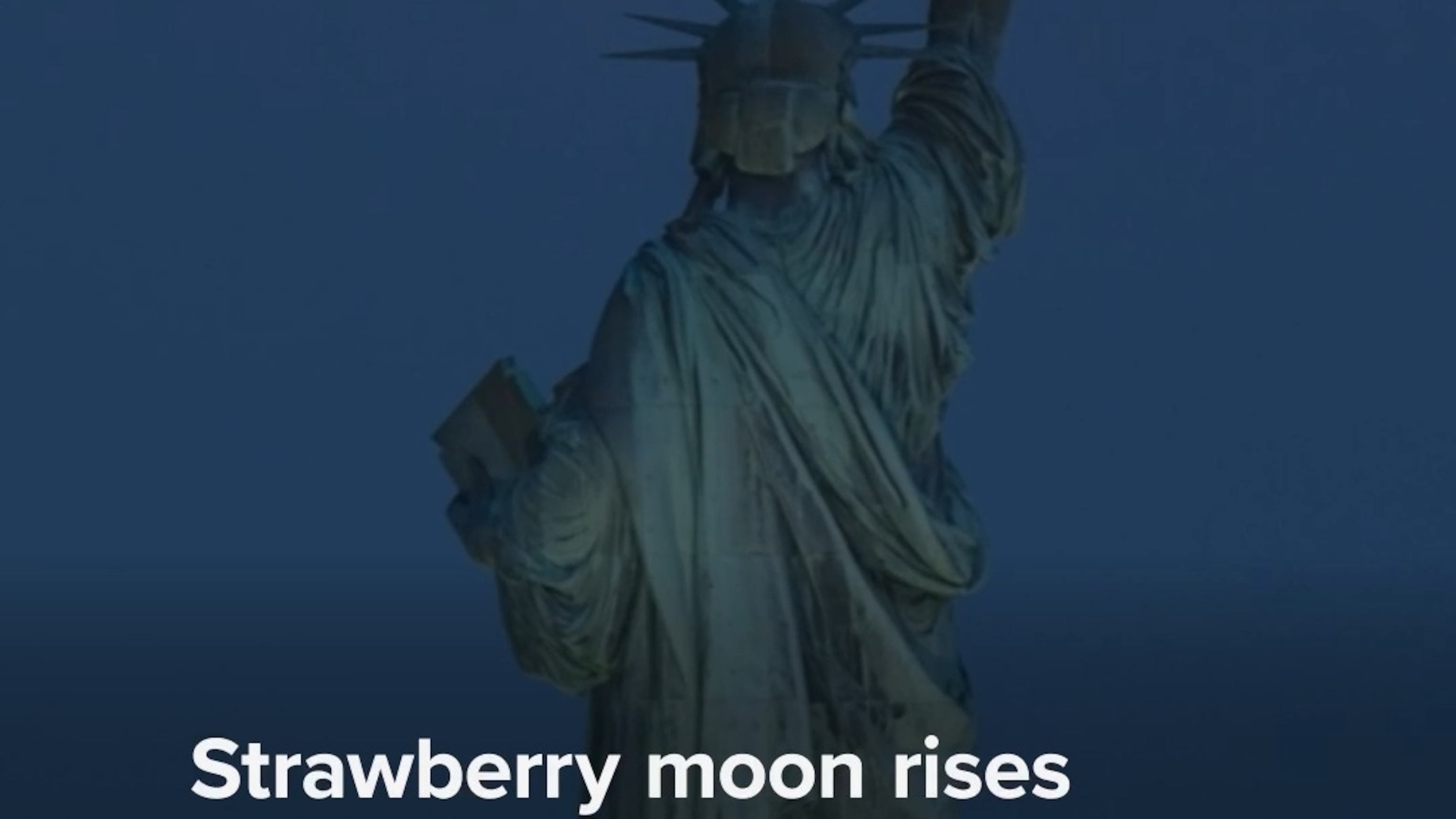 Strawberry moon rises over Statue of Liberty