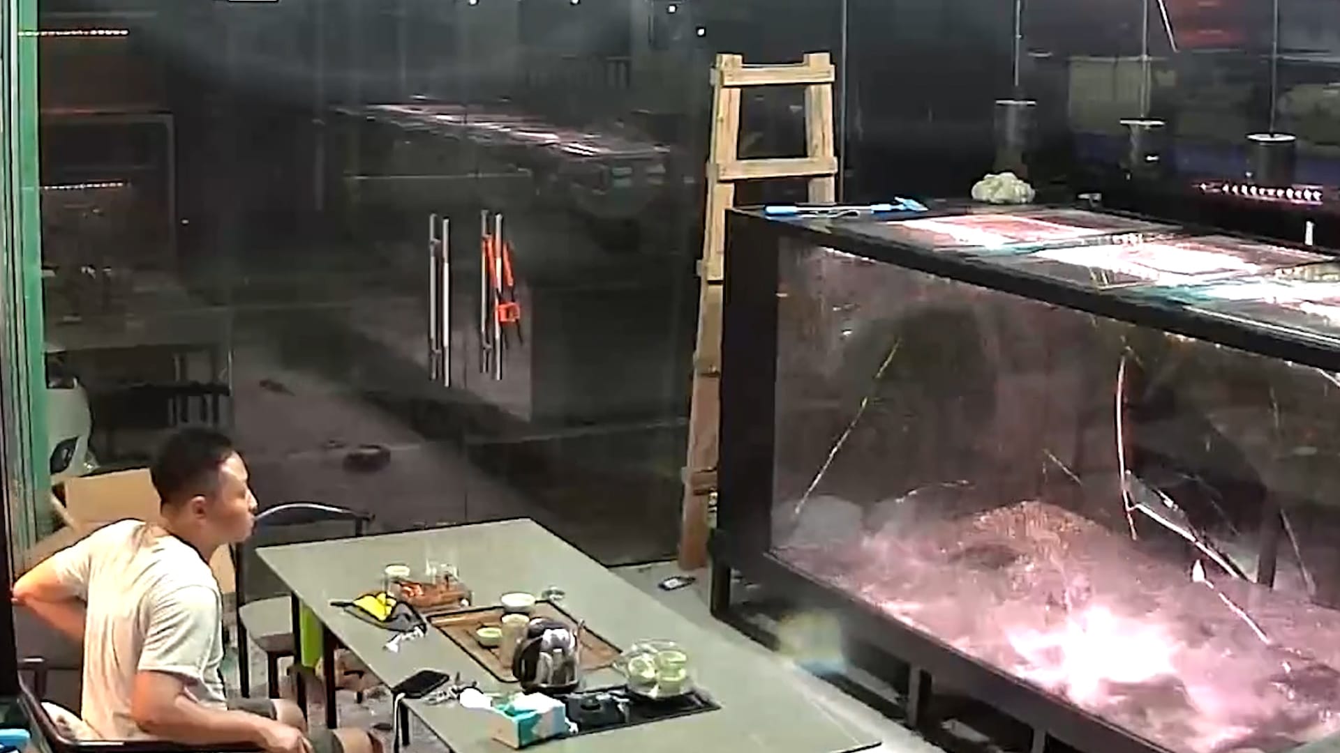 CCTV captures fish tank exploding as owner stays remarkably calm