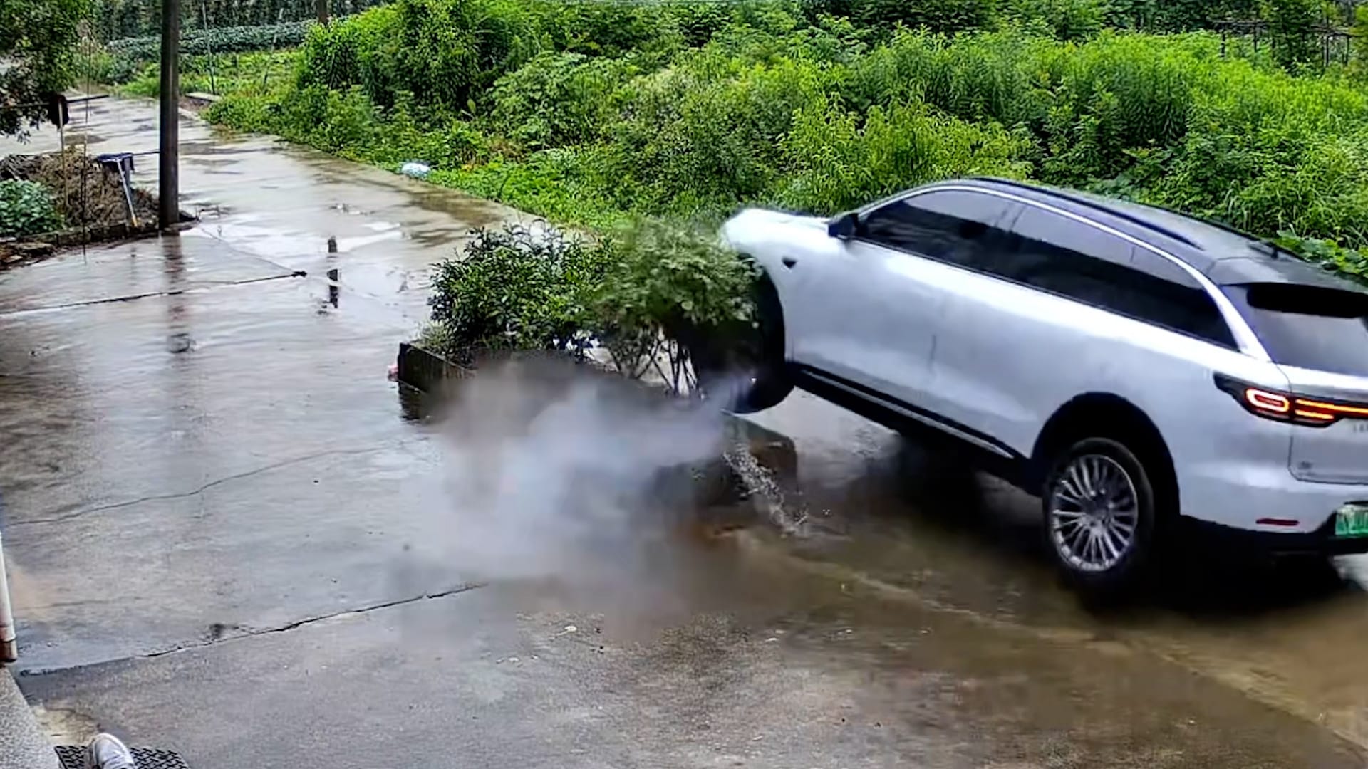Bizarre moment SUV tire bursts after hitting raised garden bed