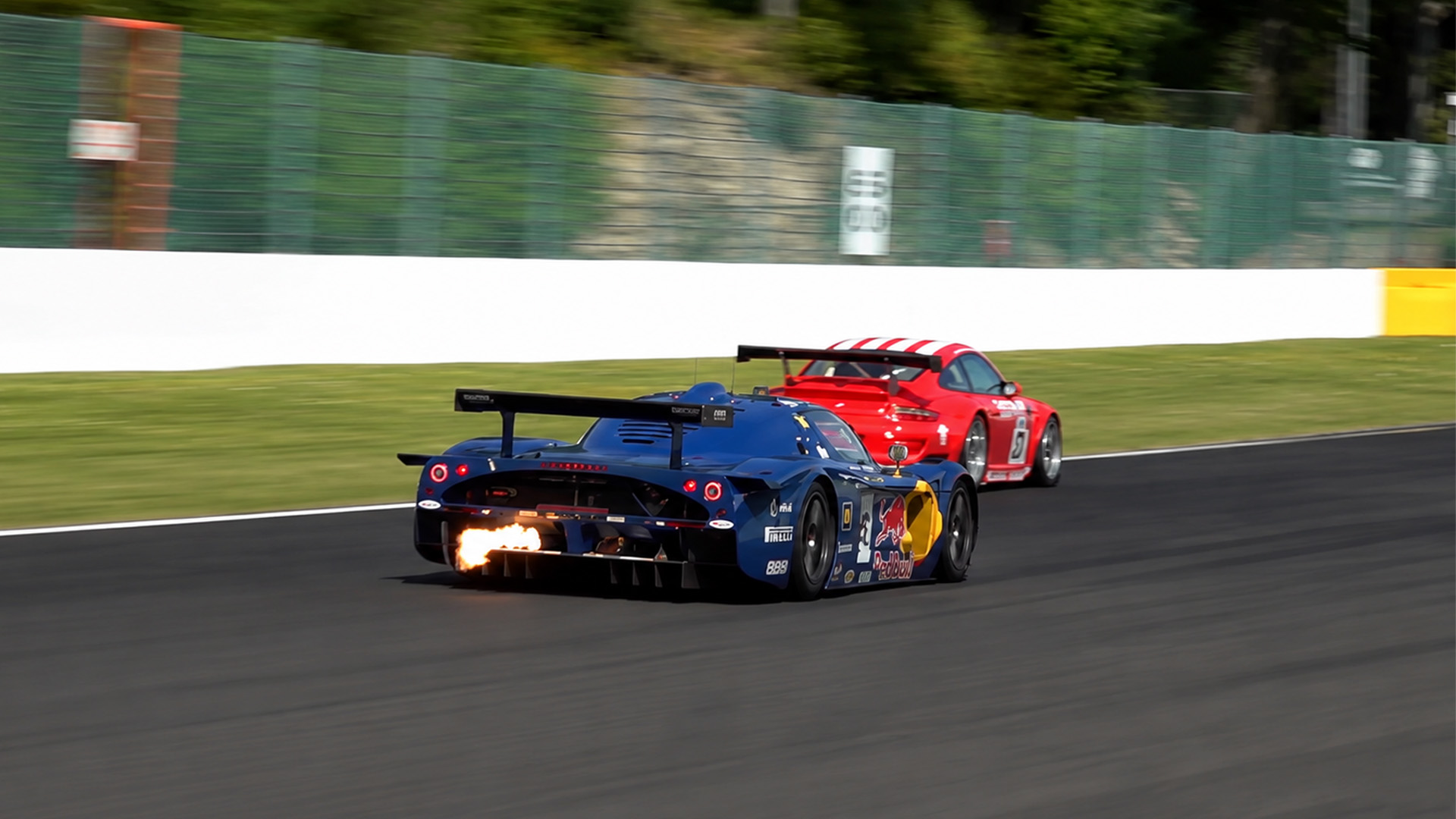 Maserati MC12 spits flames while chasing Porsche on track