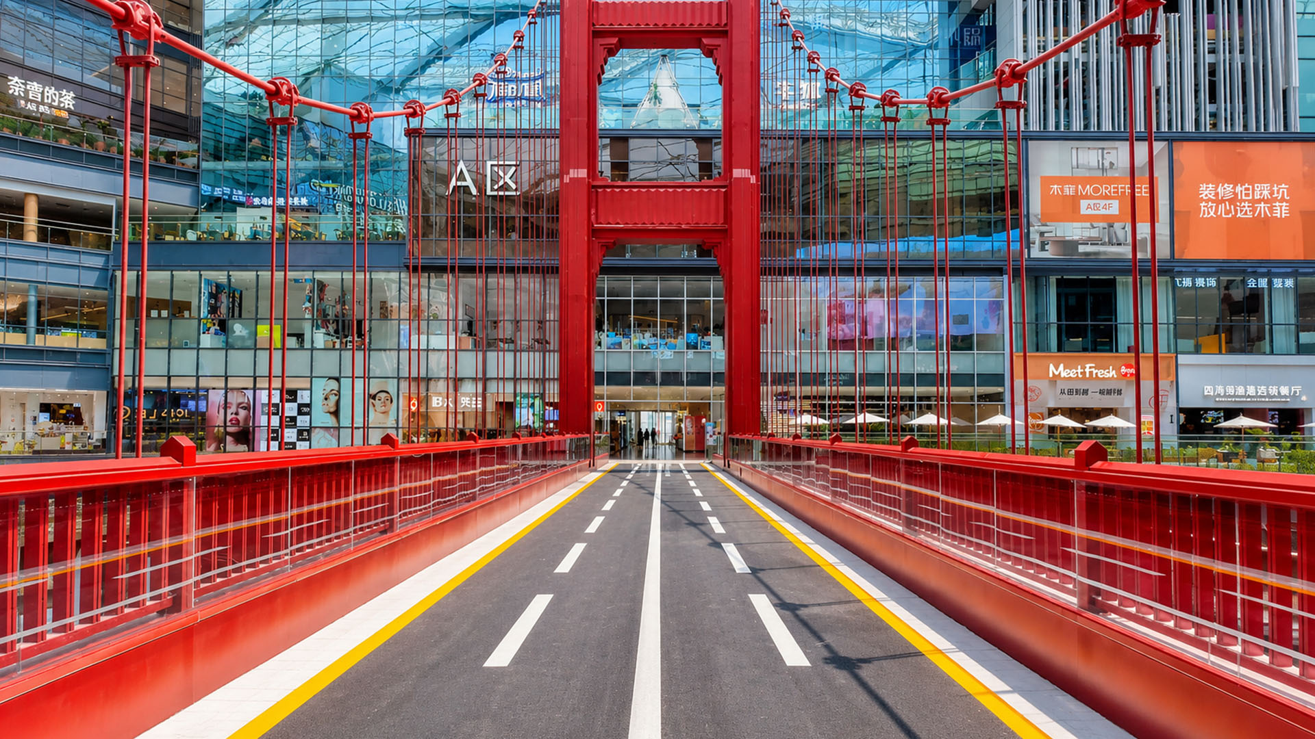 Inside a glass shopping mall where a red bridge becomes the main attraction