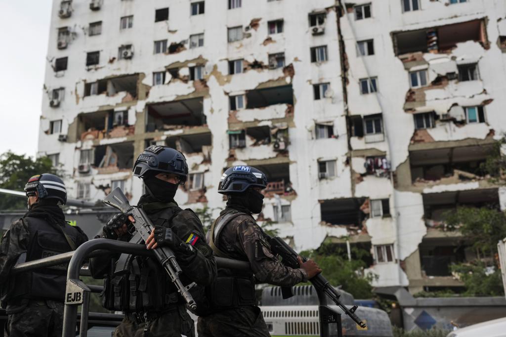 Venezuelan police officers steal money from victims among the rubble of ...