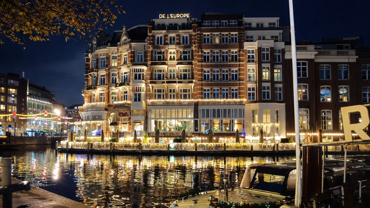 Amsterdam night lights reflect across the canal
