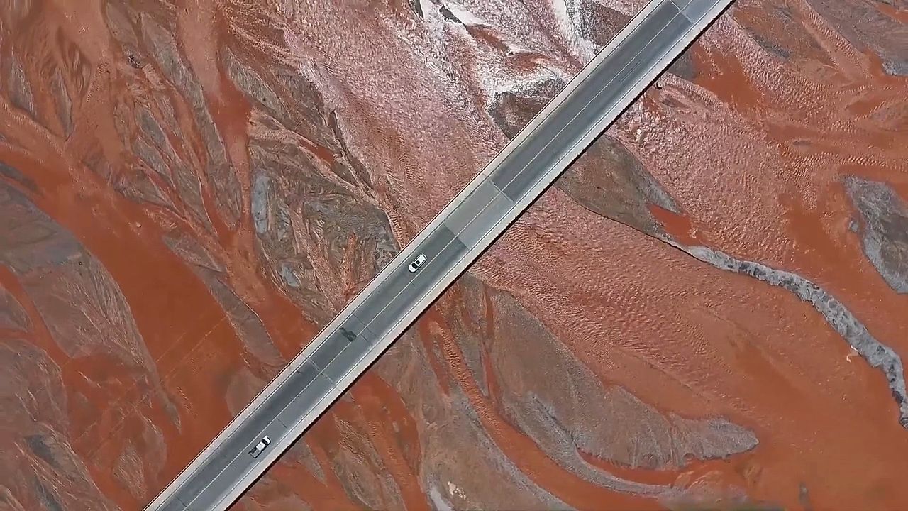 Crimson-colored river in China presents marble-like patterns from the sky
