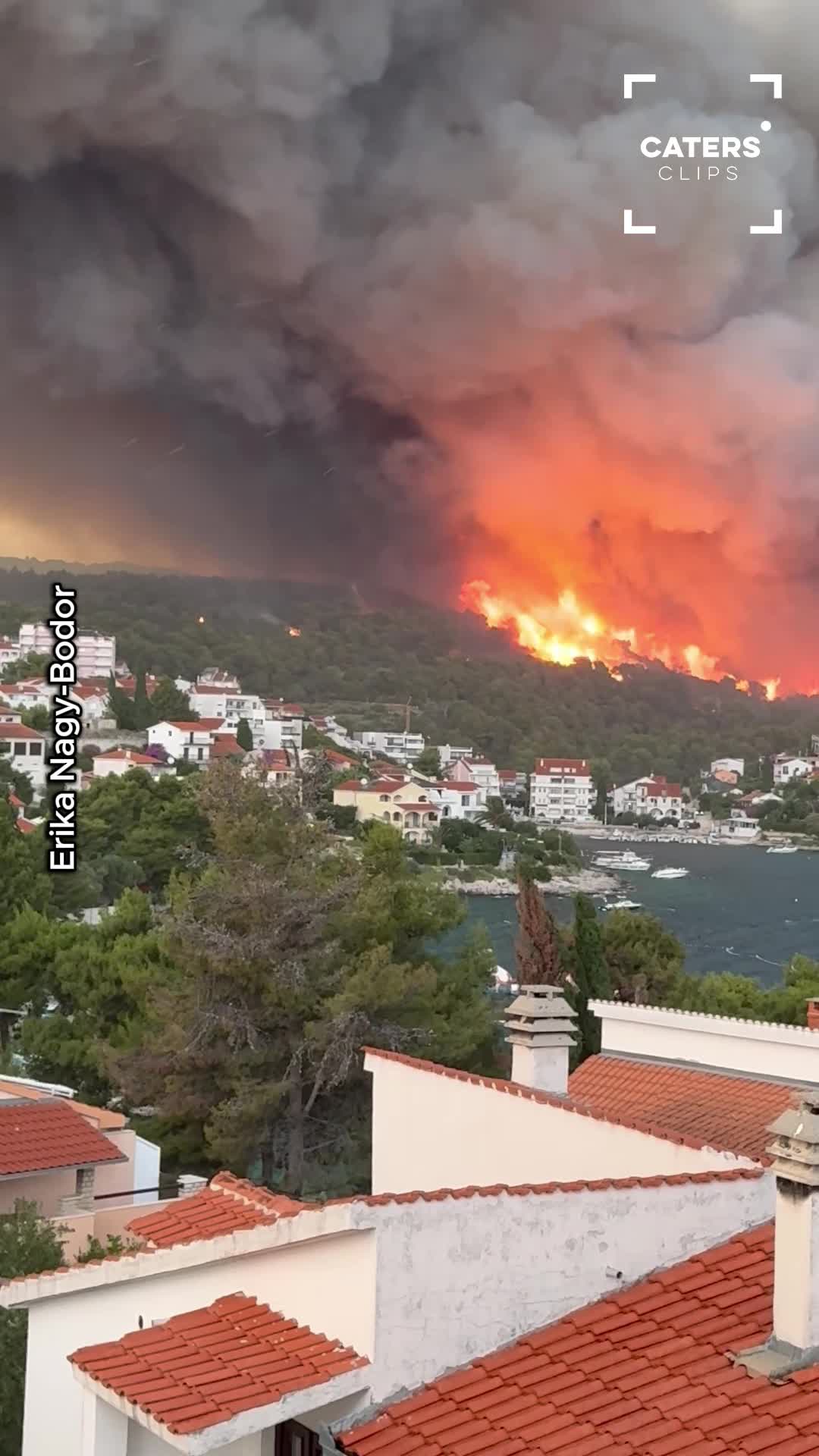 Dramatic wildfire escalates above coastal town