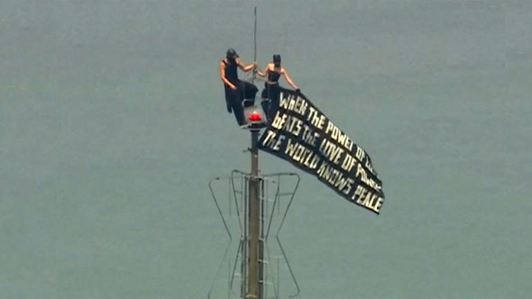 Couple climb Empire State Building spire in peace banner proposal stunt