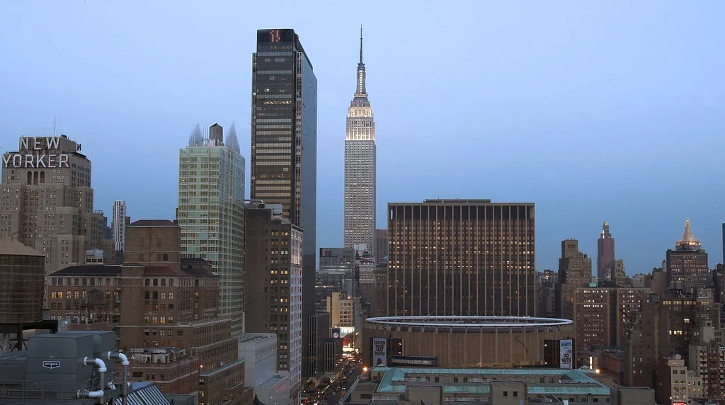 Two people climb to top of Empire State Building with flag
