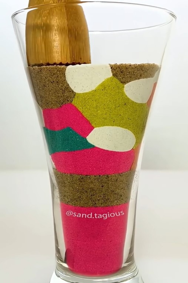 Colorful layered sand art in glass cone