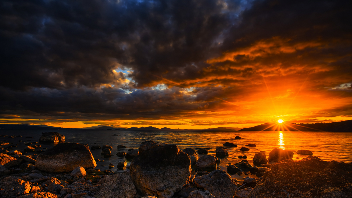 Dramatic sunset over a rocky lakeshore