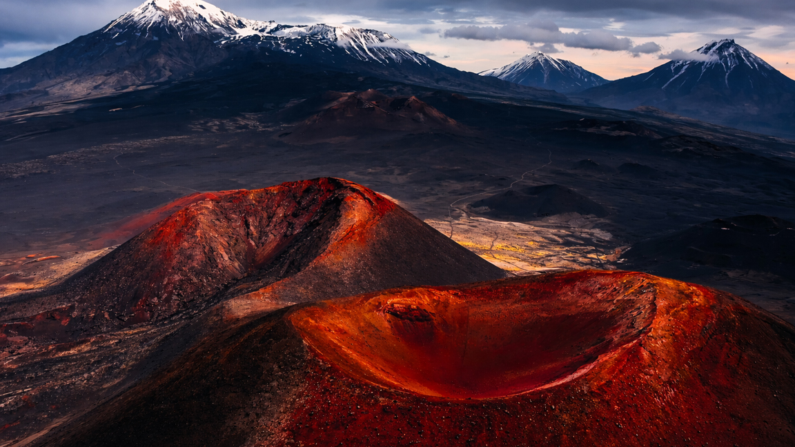 Volcanic craters beneath snow-capped mountains