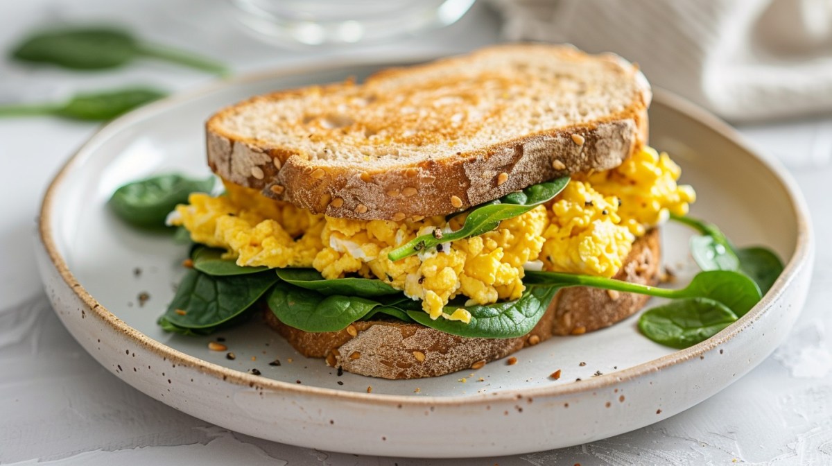 Zum Frühstück gibt’s ein Toast-Sandwich mit Rührei, Spinat und Käse
