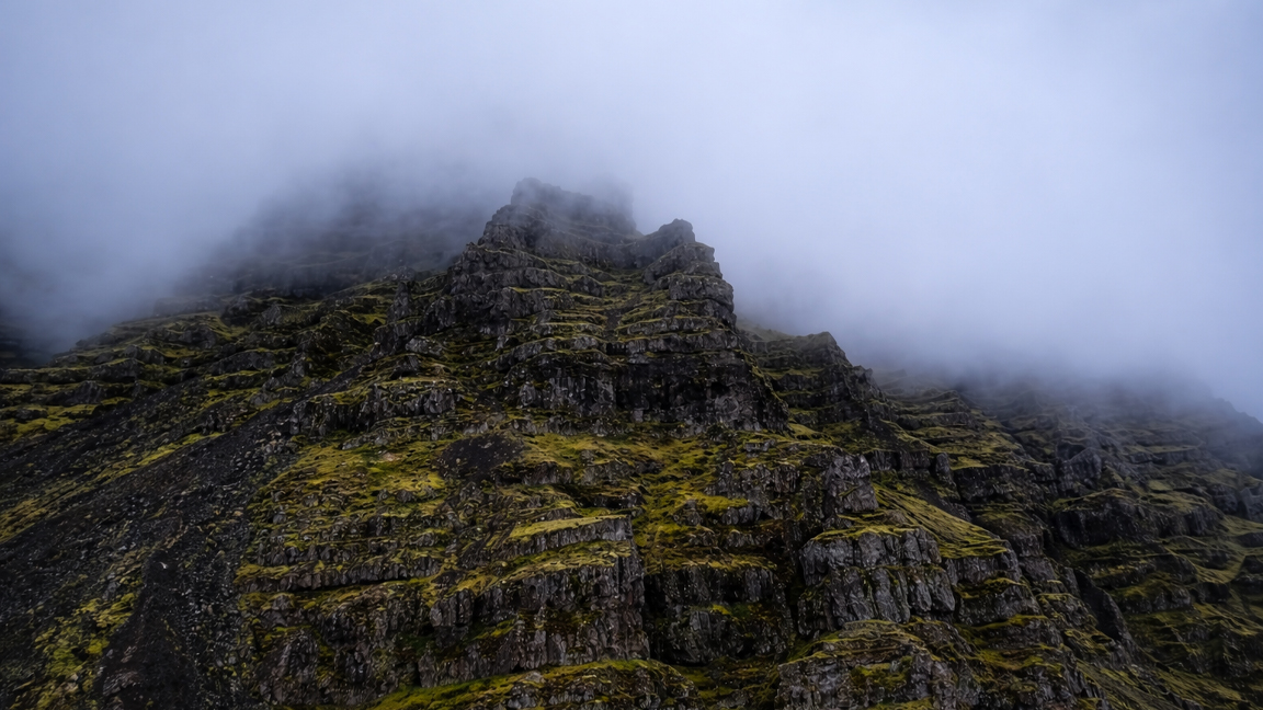 Misty mountain cliffs emerging from the fog