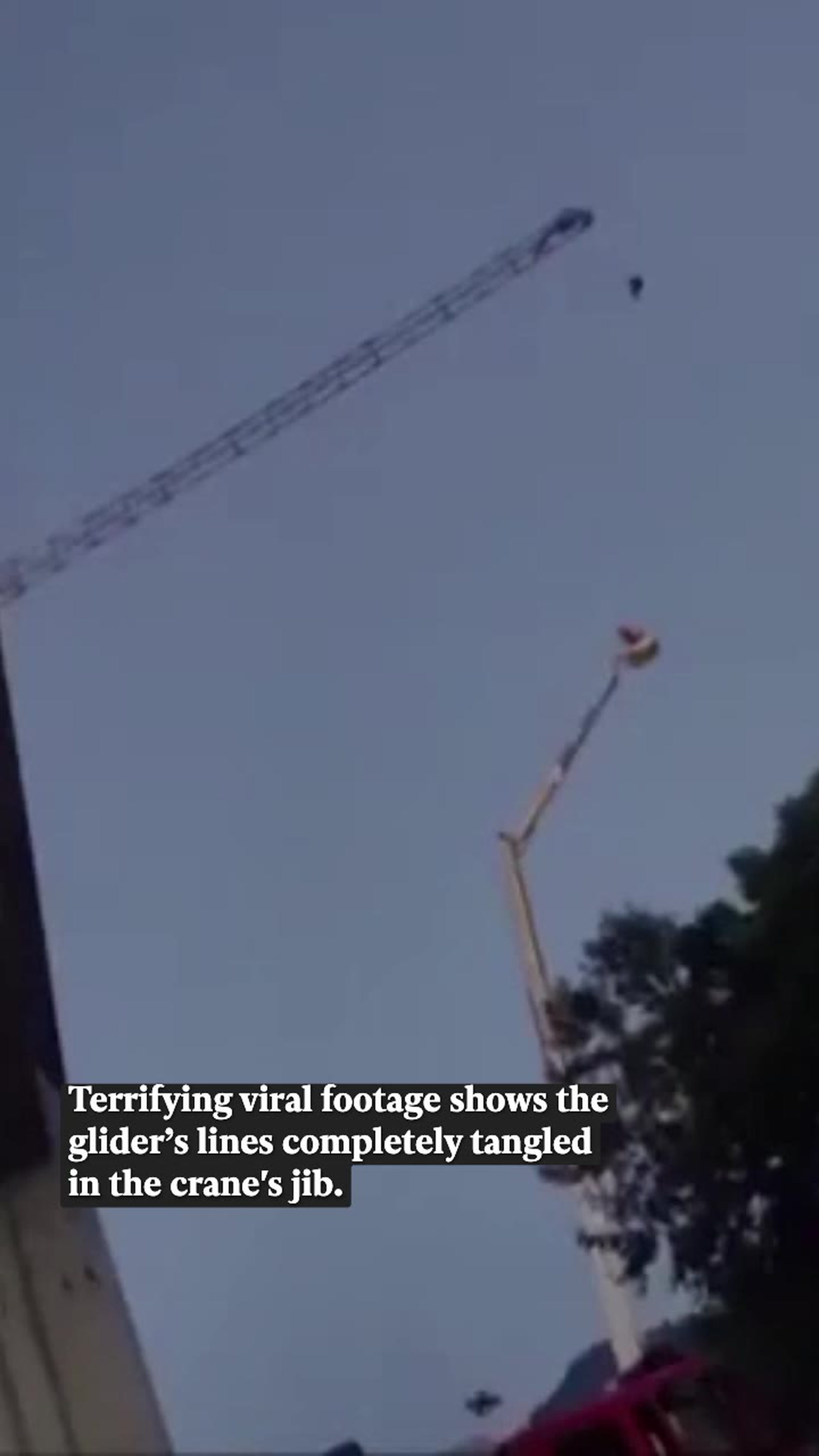 Paraglider dangles from crane after becoming snagged during jump in China