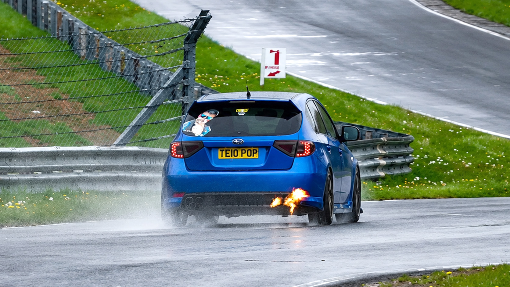 Subaru pops flames while pushing hard on track
