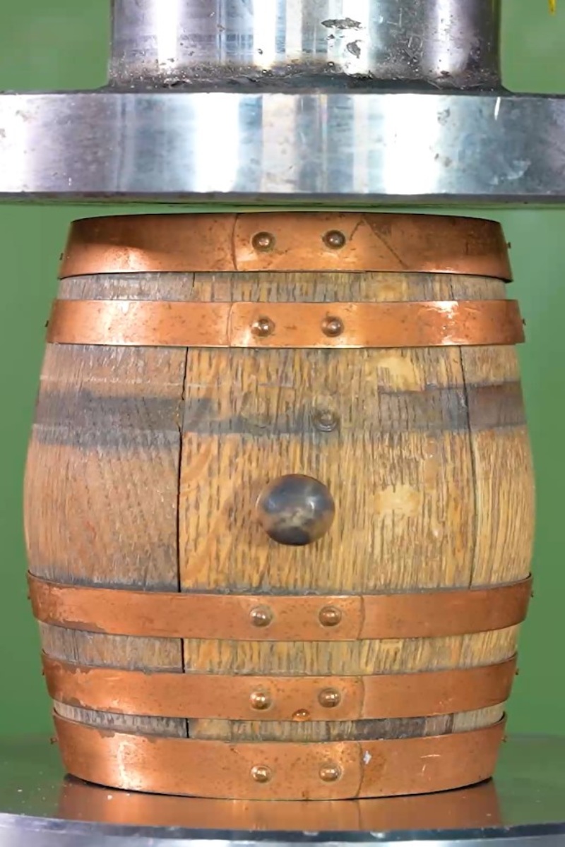 Hydraulic press crushes wooden barrel and toys
