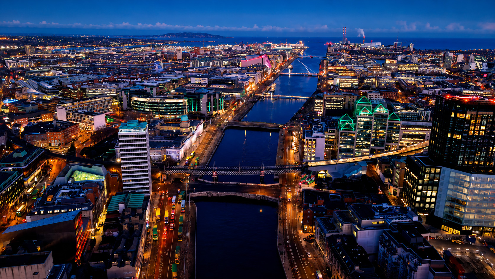 A glowing river city skyline lit up after dark