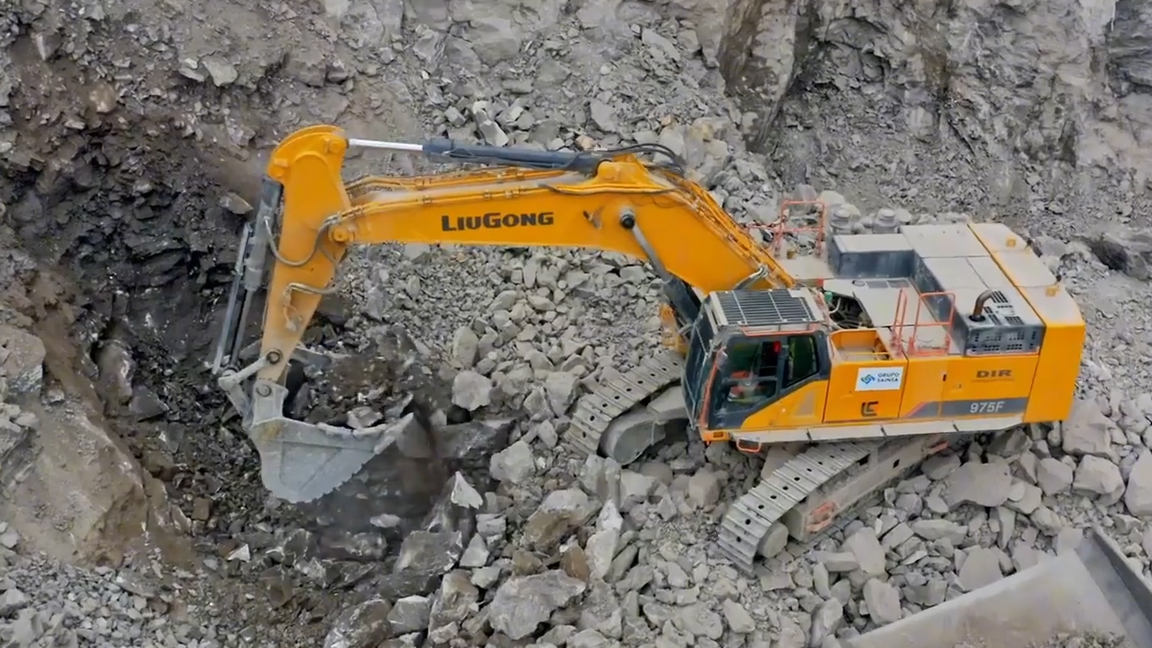 Massive excavator breaking through solid rock in a quarry
